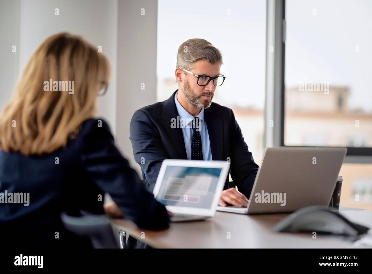 Shot of two businesspeople working on a laptop in the boardroom ...