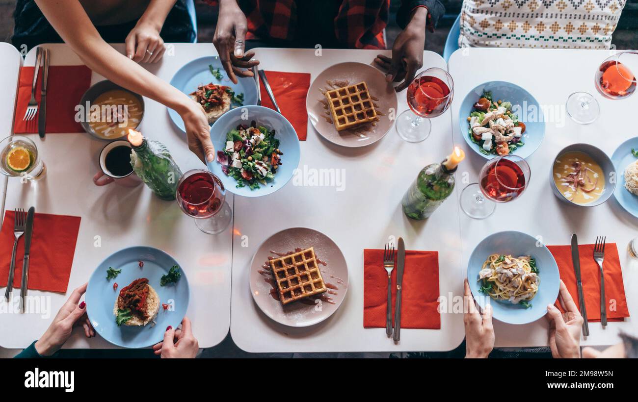 People are sitting at a table and eating. Top view Stock Photo - Alamy