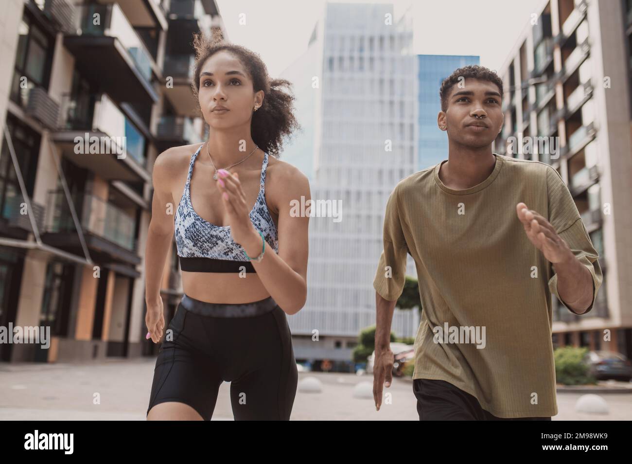 Fit girl and a sporty guy running forward Stock Photo - Alamy