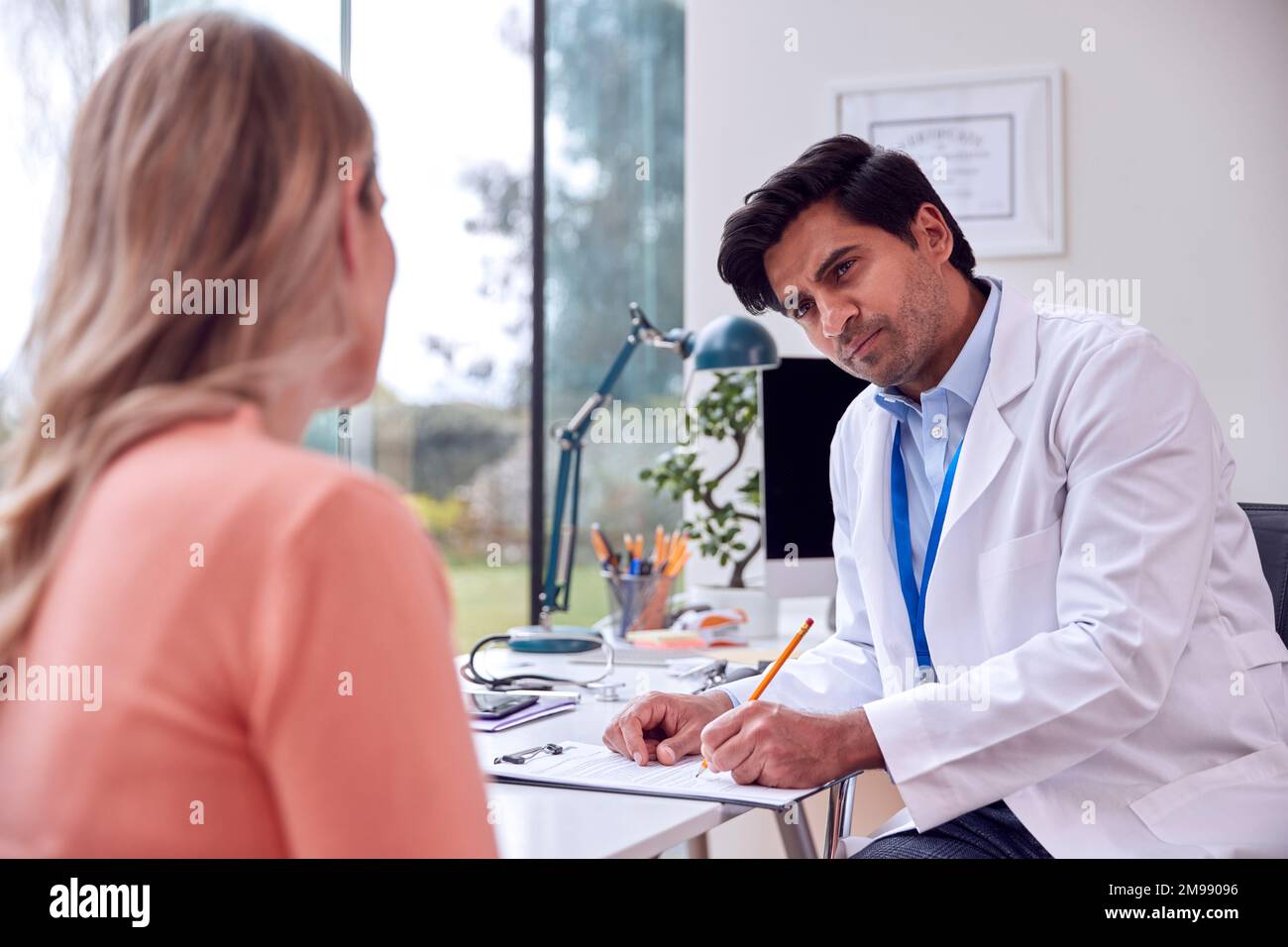 Male Doctor Or GP Meeting Mature Female Patient For Appointment In ...