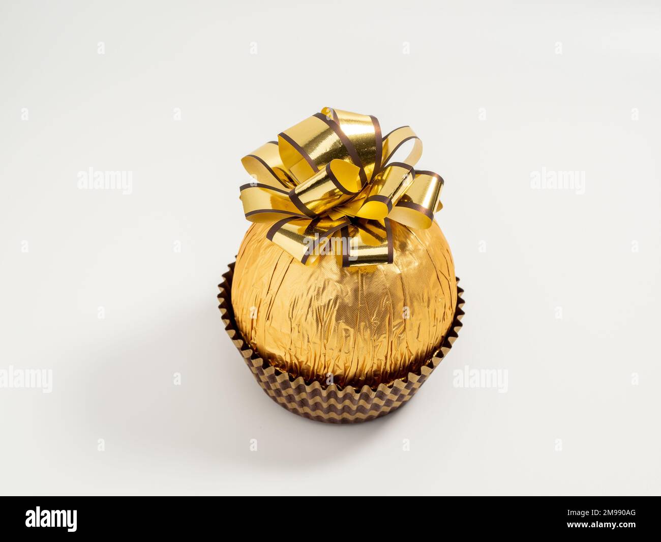 Chocolate balls wrapped in golden paper. Chocolate bar with golden bow ...