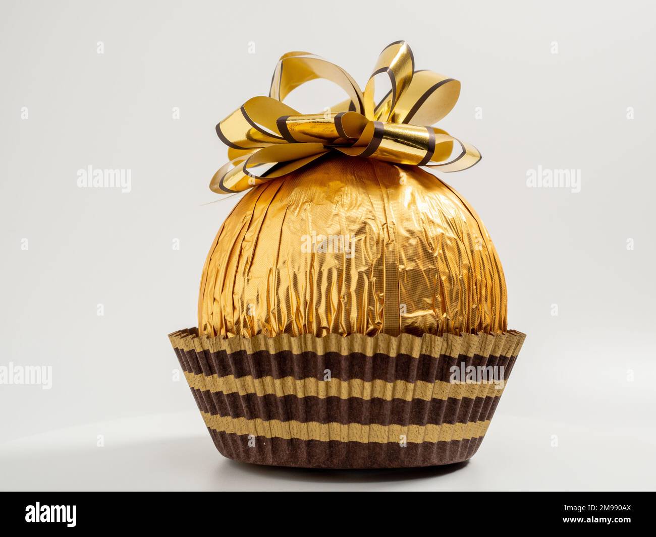 Chocolate balls wrapped in golden paper. Chocolate bar with golden bow ...