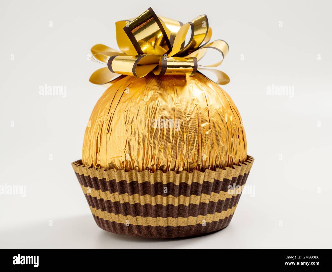 Chocolate balls wrapped in golden paper. Chocolate bar with golden bow ...
