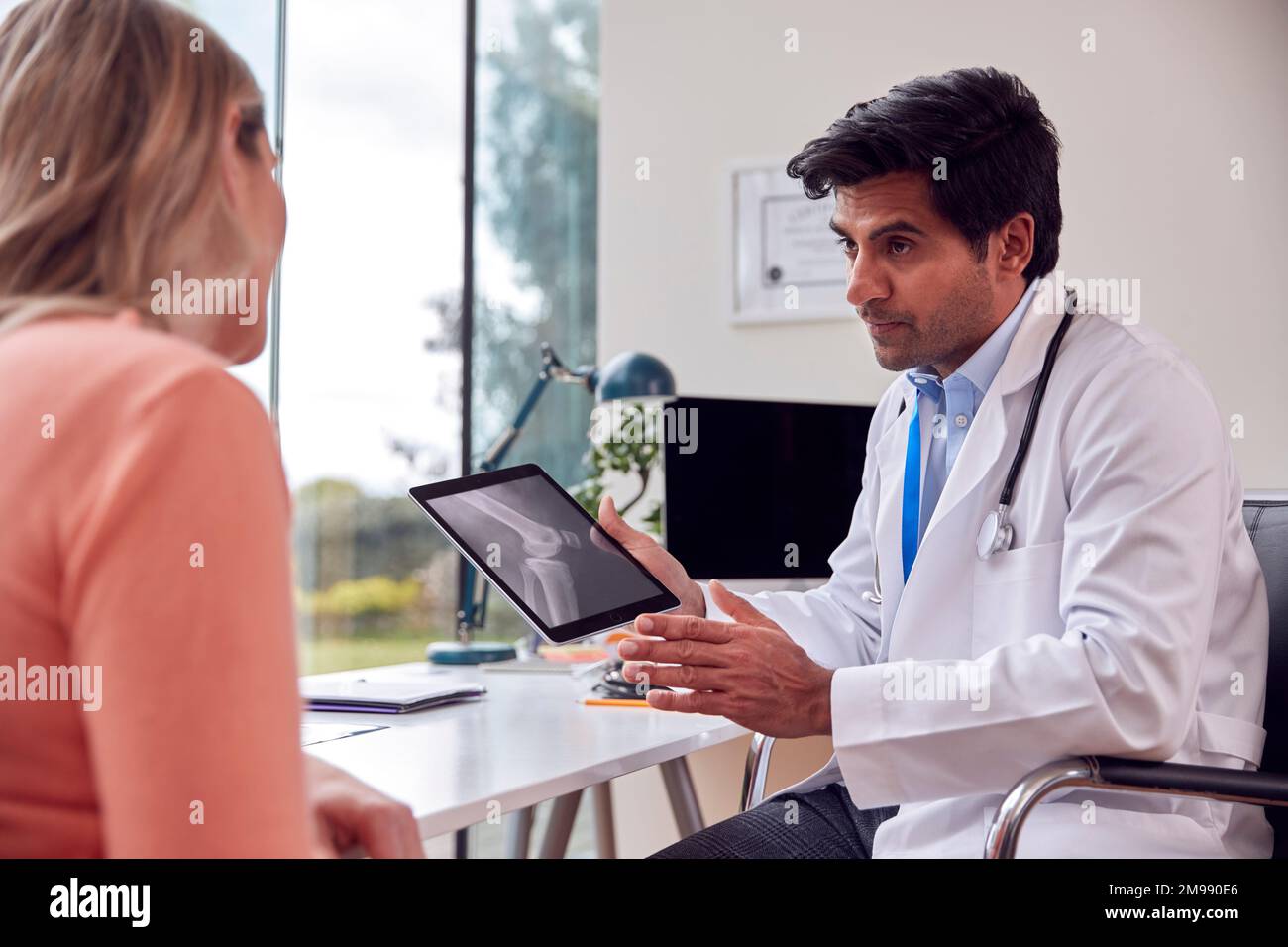 Doctor Wearing White Coat In Office Showing Mature Female Patient X-Ray ...
