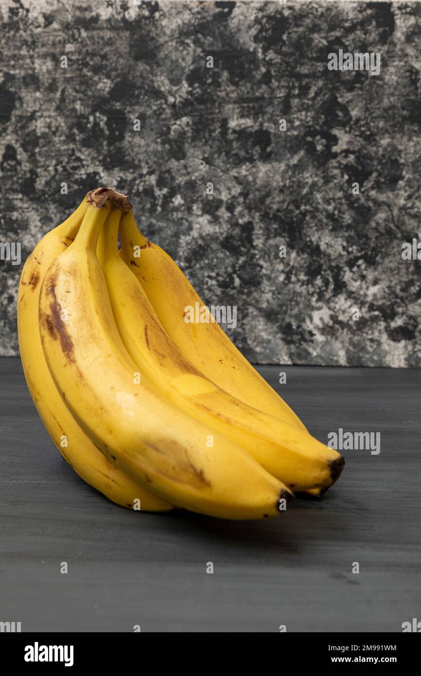 Group of bananas on a gray table and copy space Stock Photo - Alamy