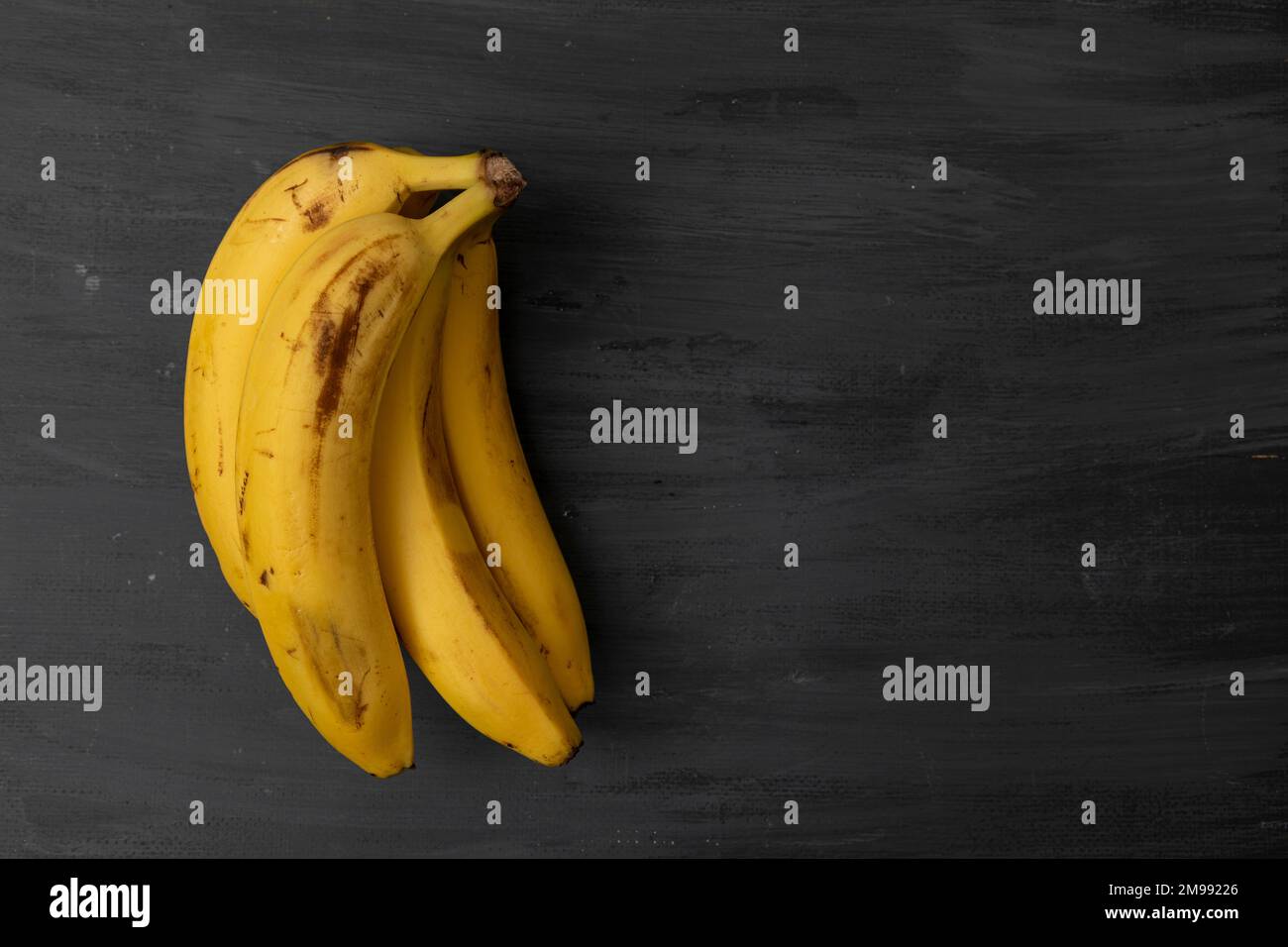 Group of bananas on a gray table and copy space Stock Photo - Alamy