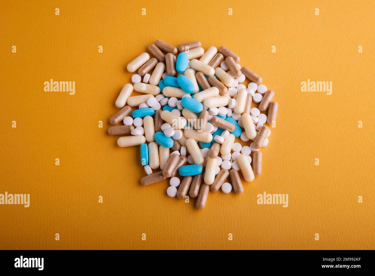 A high-angle shot of blue, brown, and white oval medicines on the ...