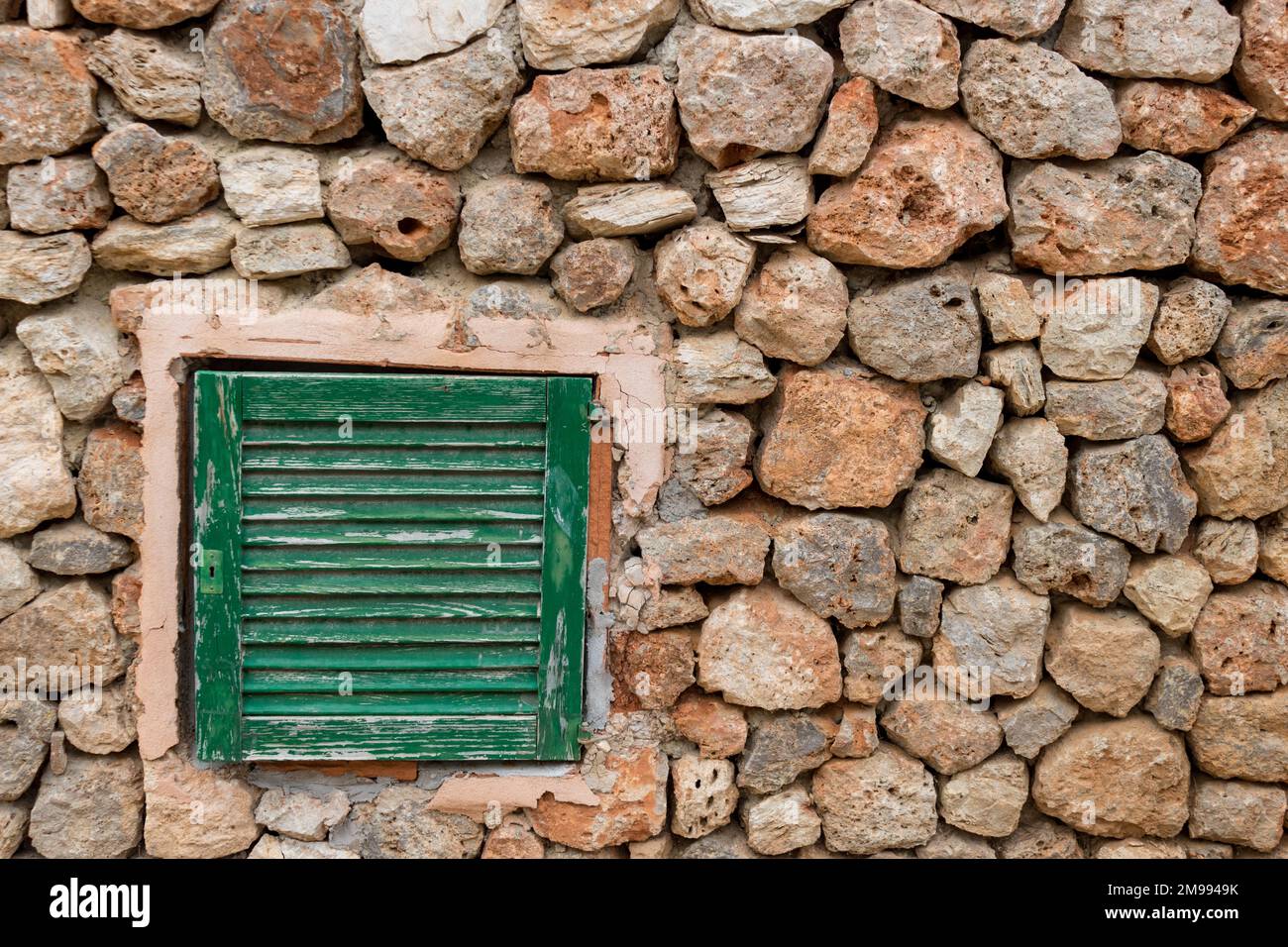 Green wooden window on ancient stone wall in Cala ratjada, Mallorca ...