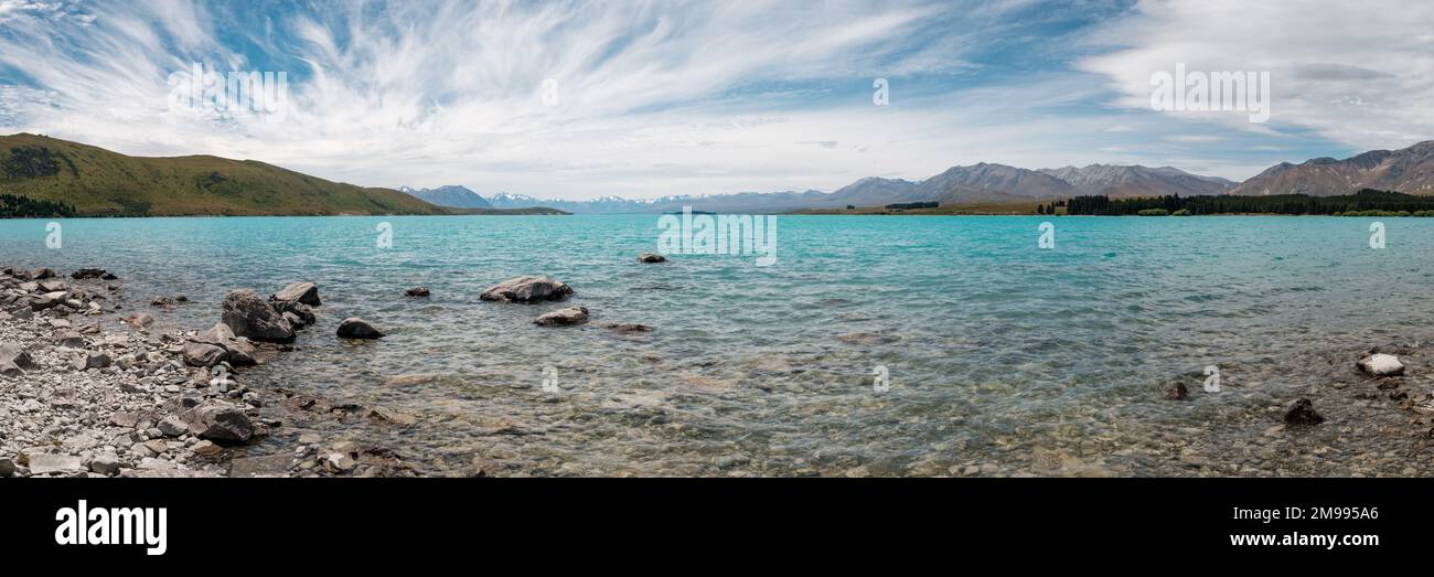 Panoramic view of wispy clouds and blue skies over the azure blue water ...