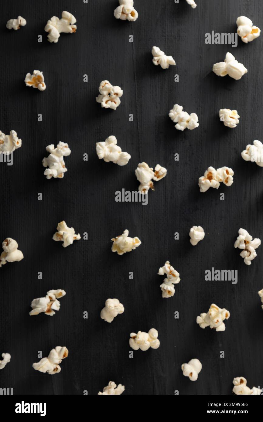 Top view of a group of popcorn, arranged in a pattern, on a black ...