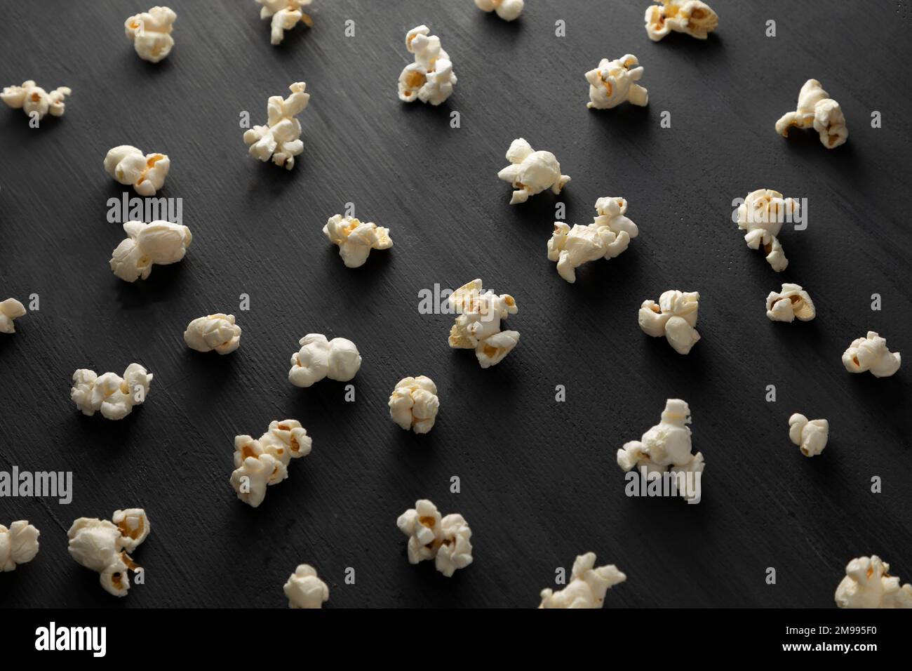 Top view of a group of popcorn, arranged in a pattern, on a black ...