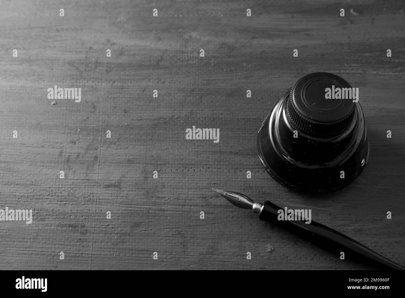 Fountain pen with its inkwell on a gray wooden base, with copy space ...
