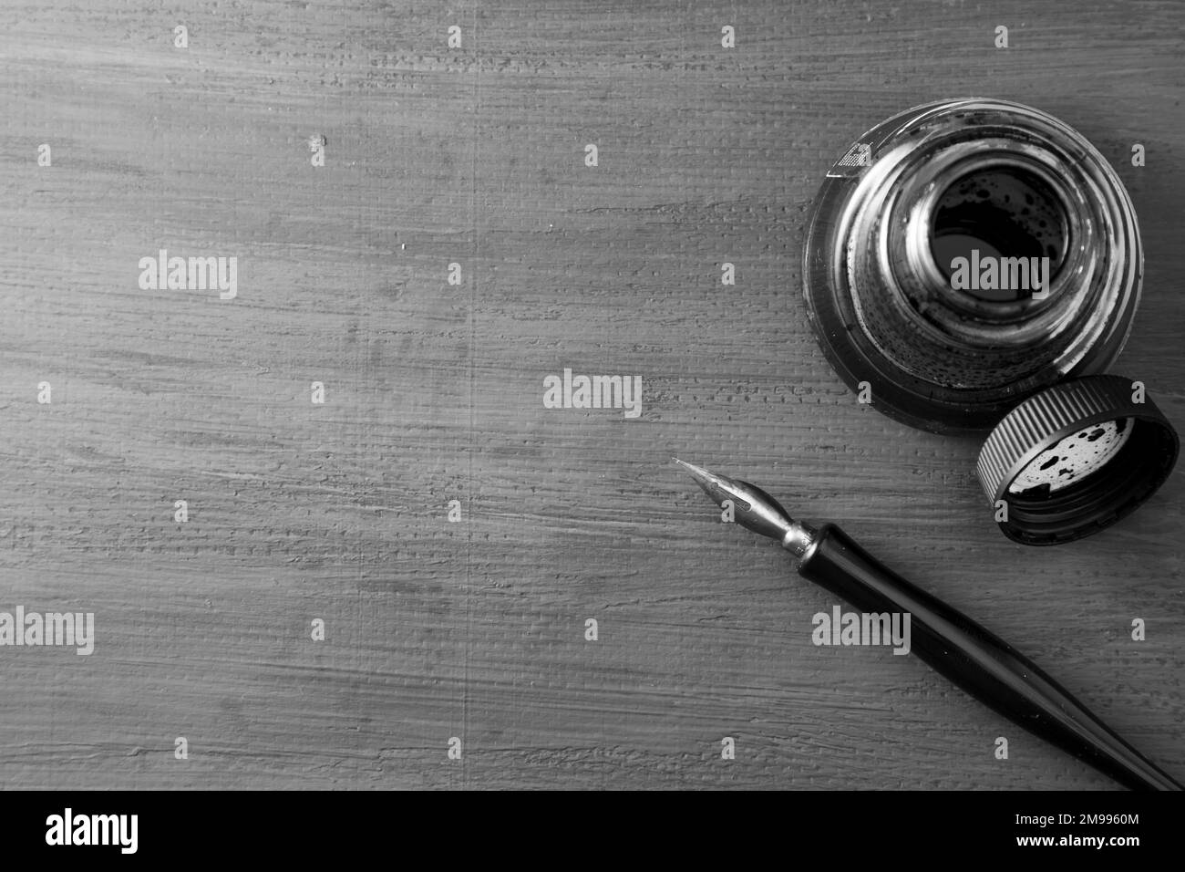 Fountain pen with its inkwell on a gray wooden base, with copy space ...
