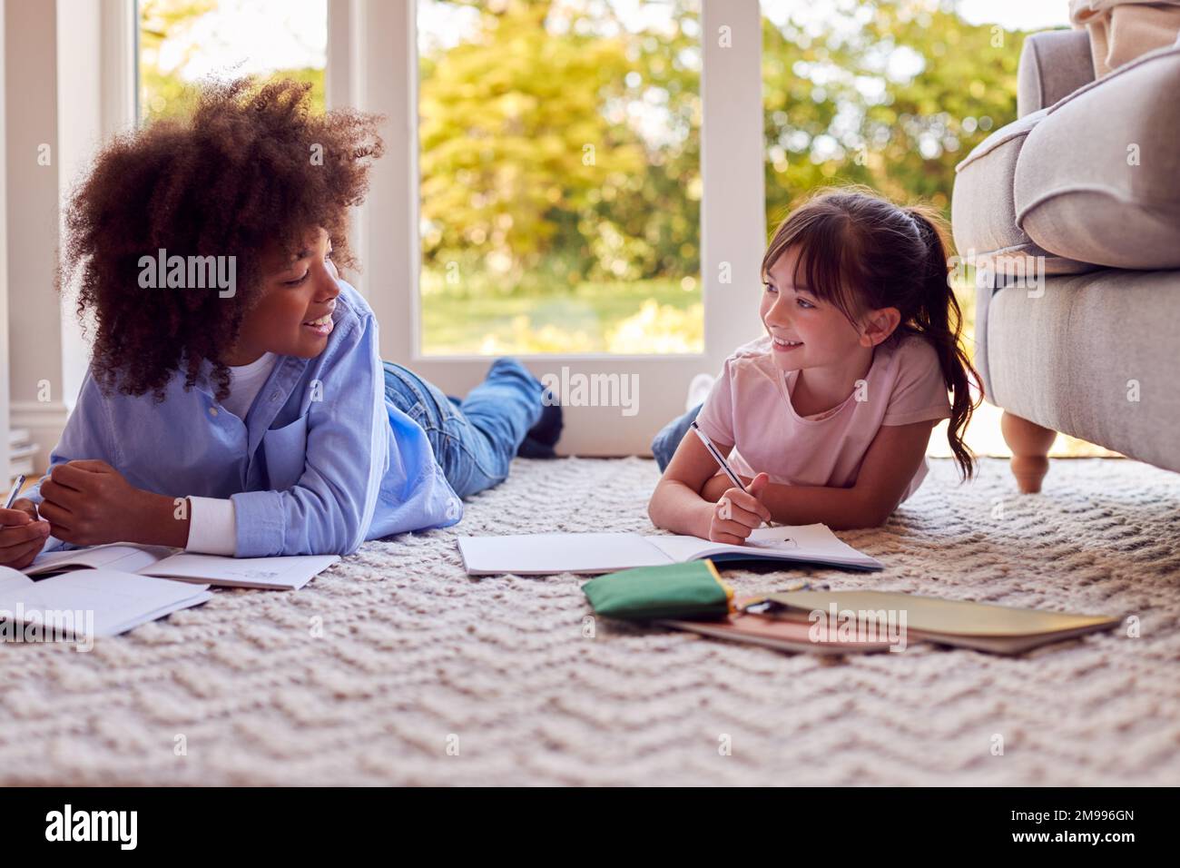 Kids doing homework lying on hi-res stock photography and images - Alamy