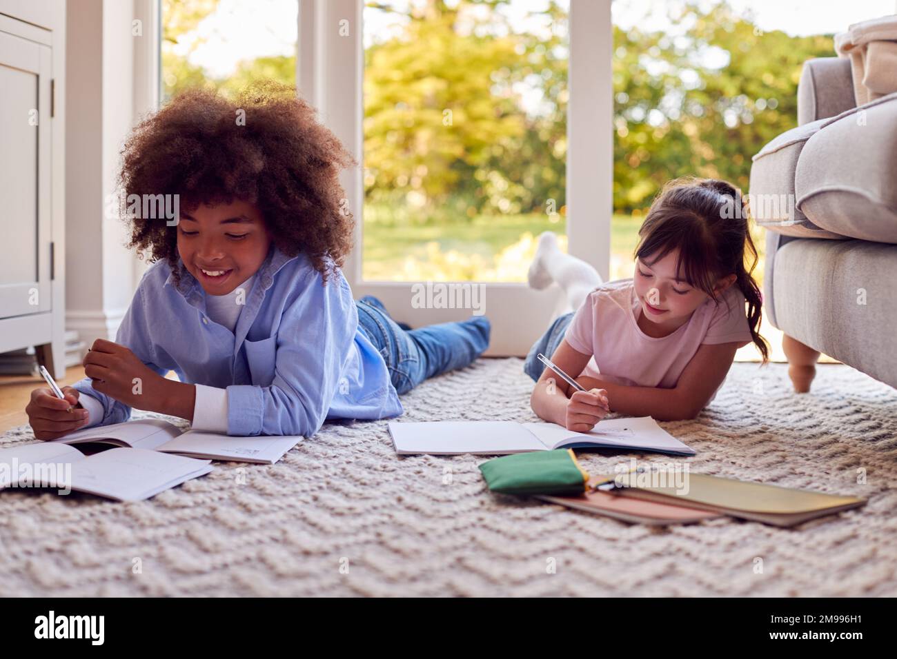 Kids doing homework lying on hi-res stock photography and images - Alamy