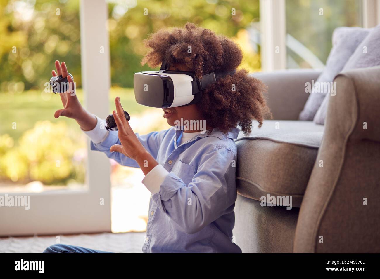 Boy Sitting On Floor In Lounge Wearing VR Headset Playing Game Stock ...