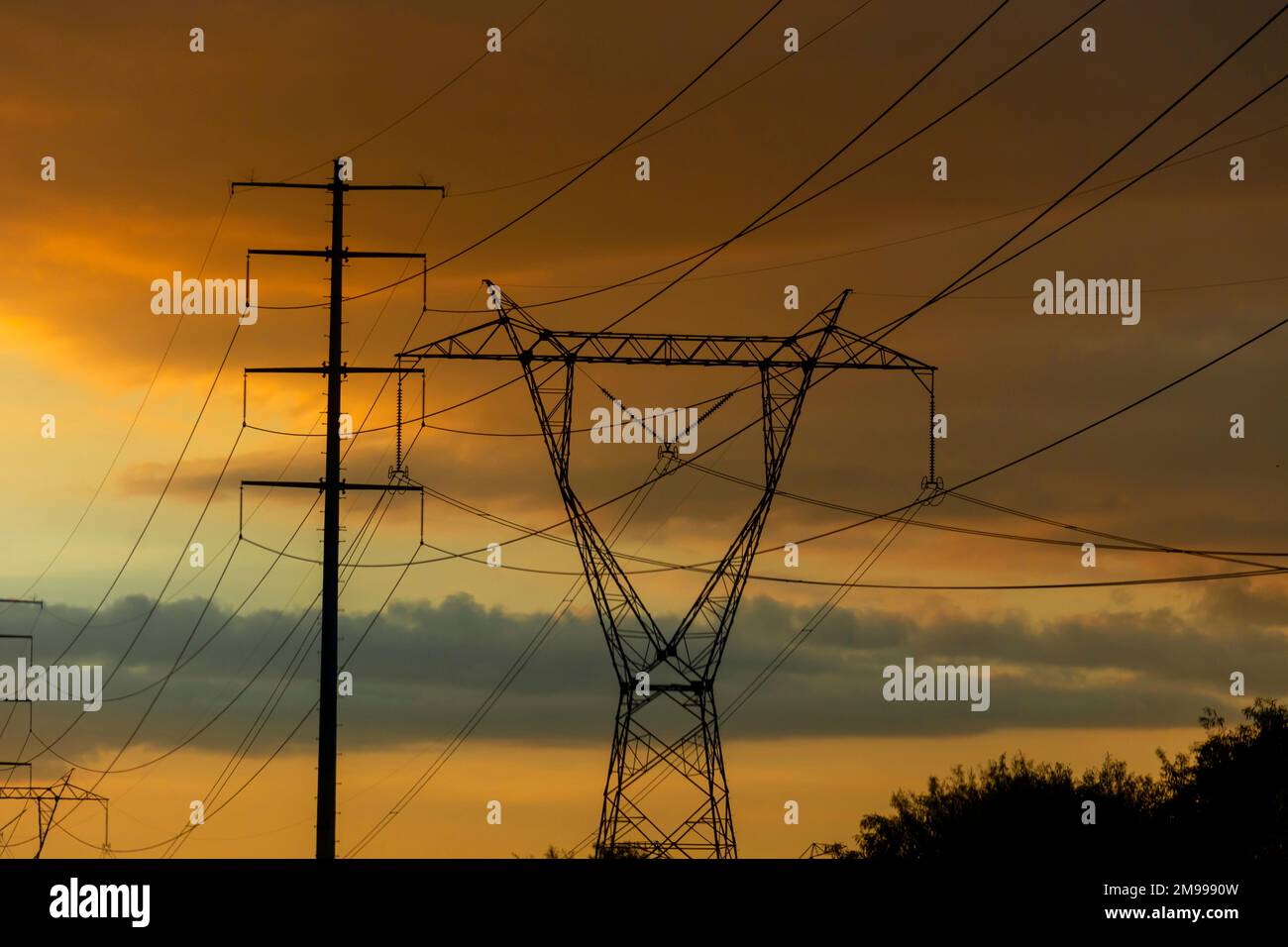 high voltage pylons at sunset with yellow sky Stock Photo - Alamy