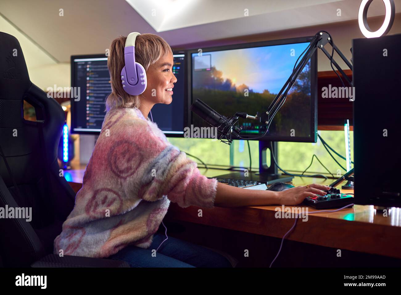 Woman Gaming At Home Sitting At Desk With Multiple Monitors Stock Photo ...