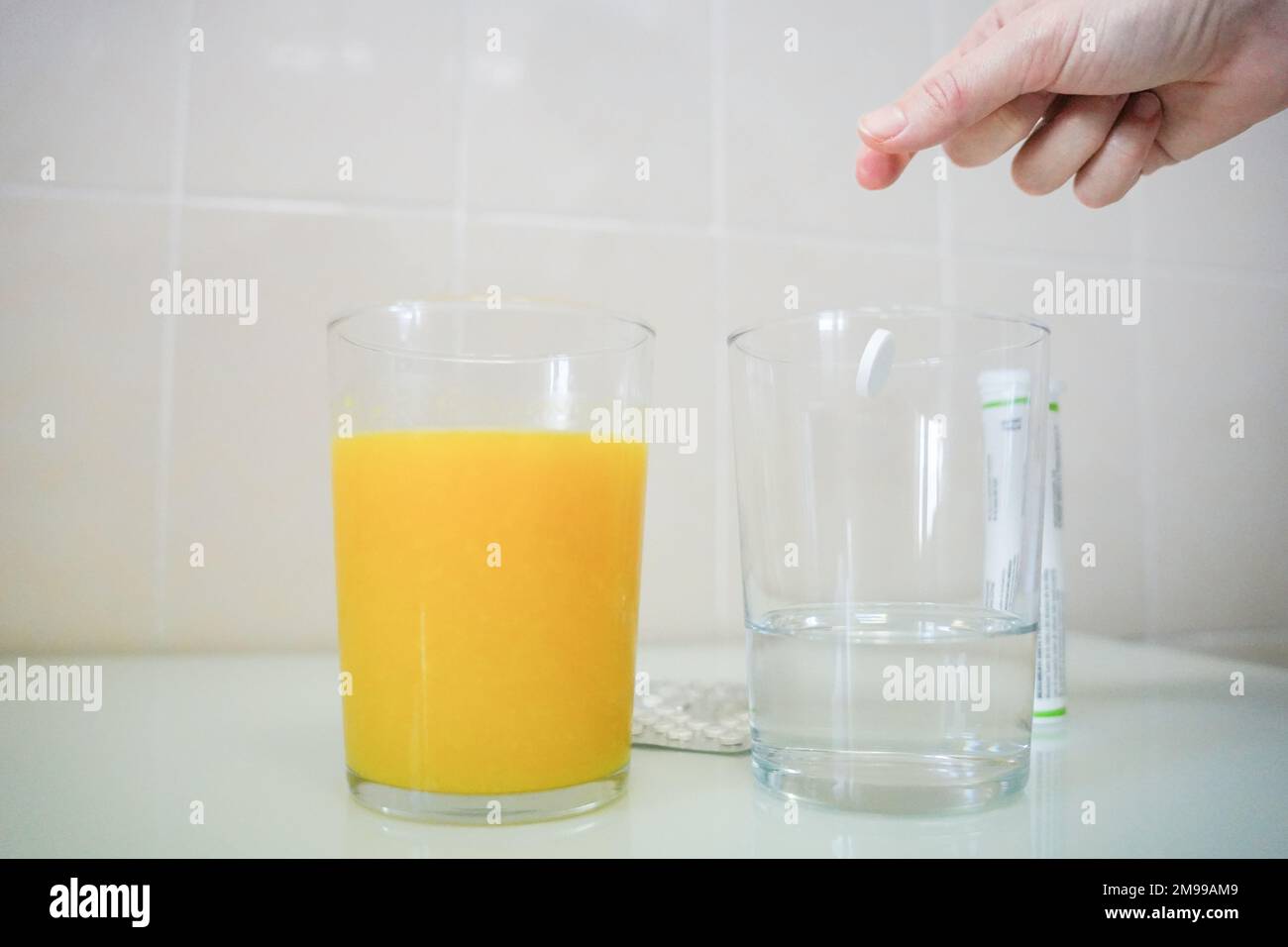 glass of orange juice with a pill in a glass of water. virus immunity ...