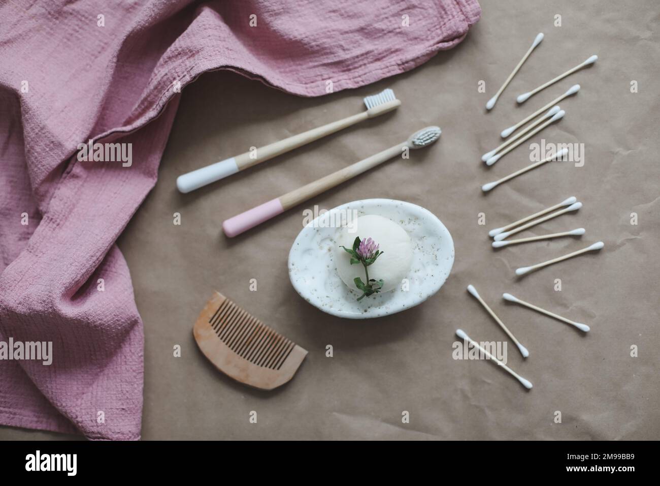 Soap bar or solid shampoo on a soap dish, bamboo toothbrush and towel ...