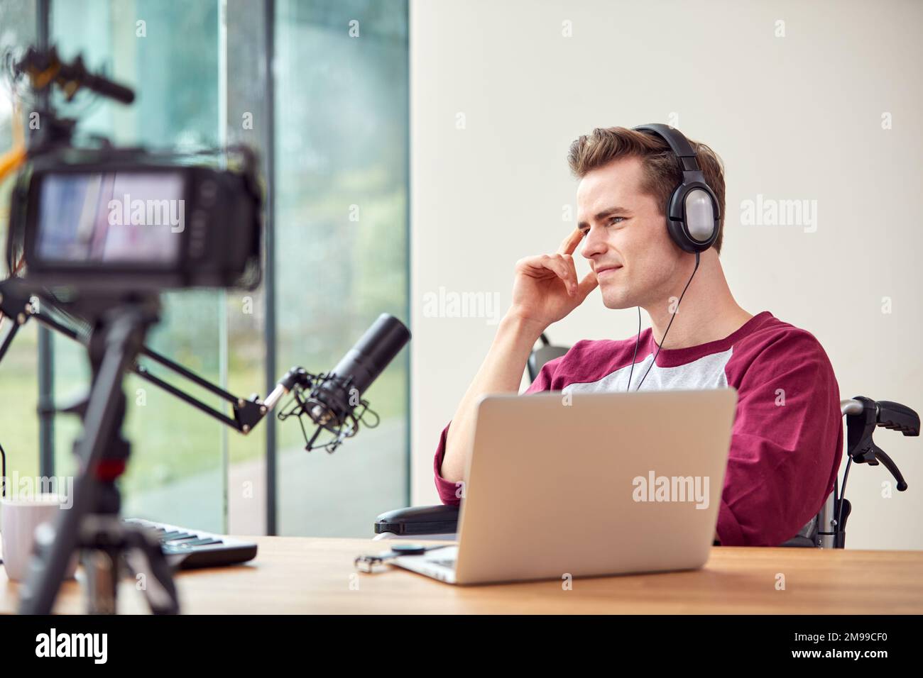 Male Vlogger With Laptop Recording Video At Home With Camera Stock ...