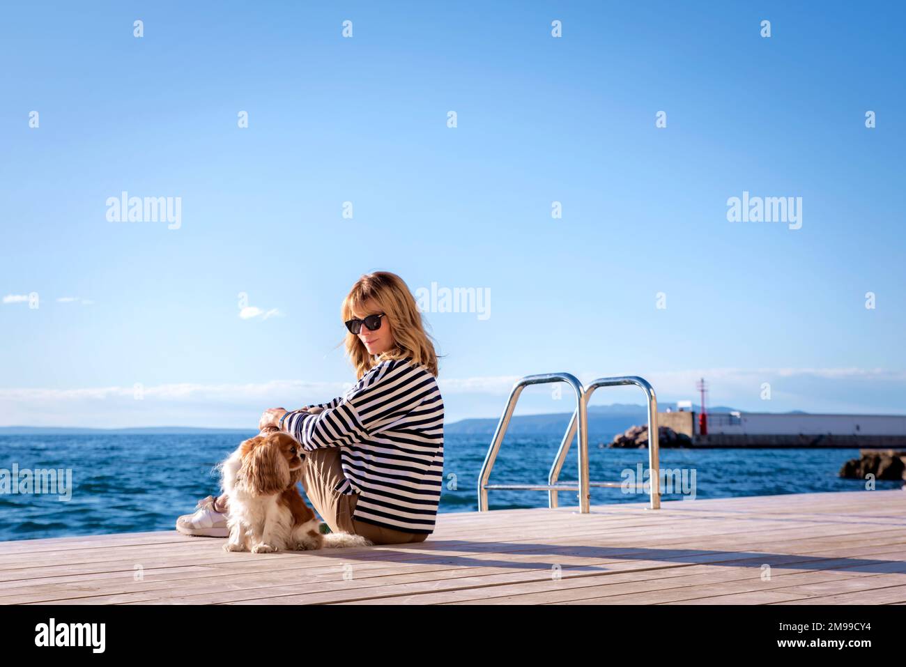 Rear view shot of a woman wearing striped sweater and sunglasses while ...