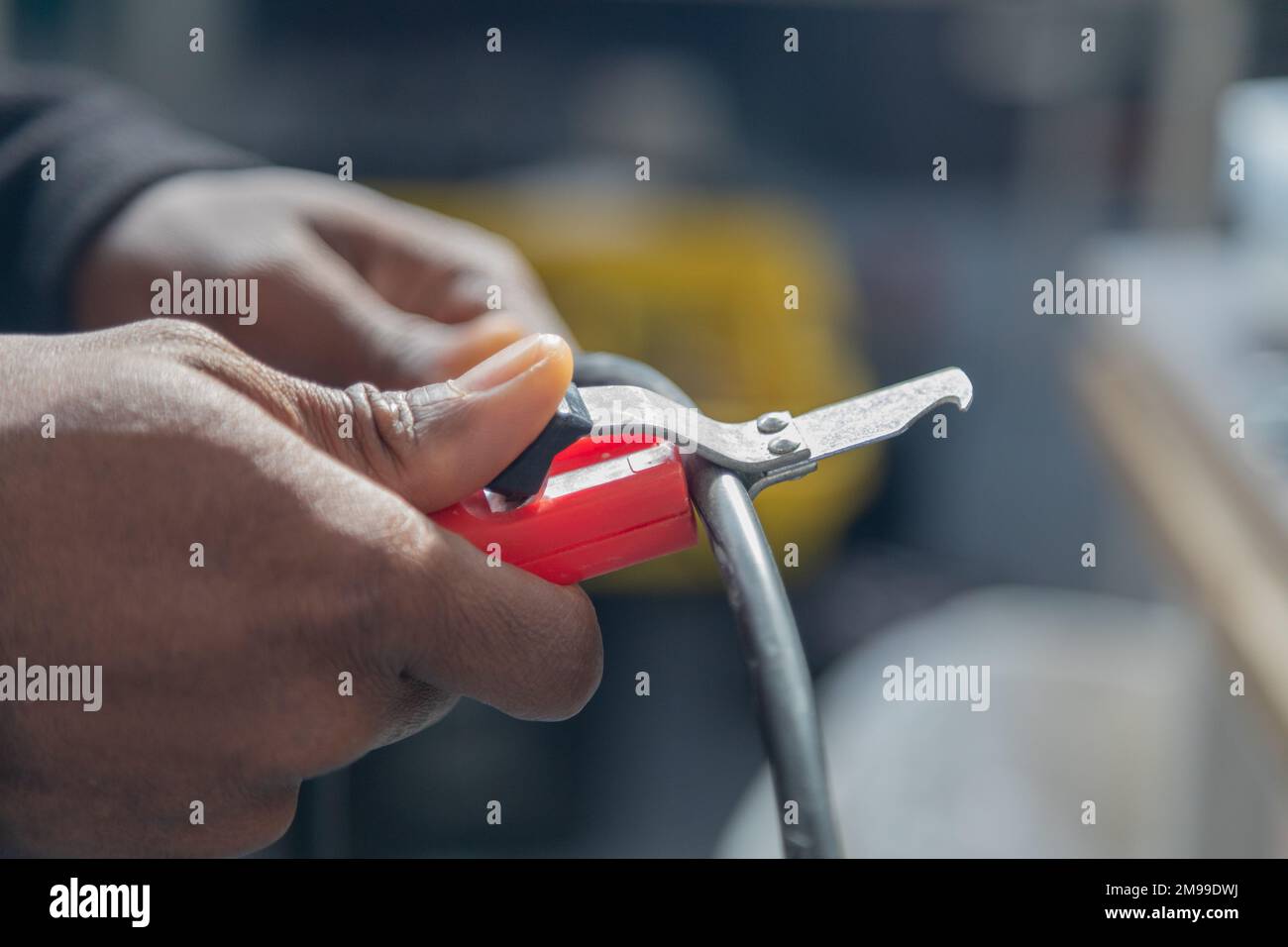 A closeup of a man stripping a cable with a wire stripper Stock Photo ...