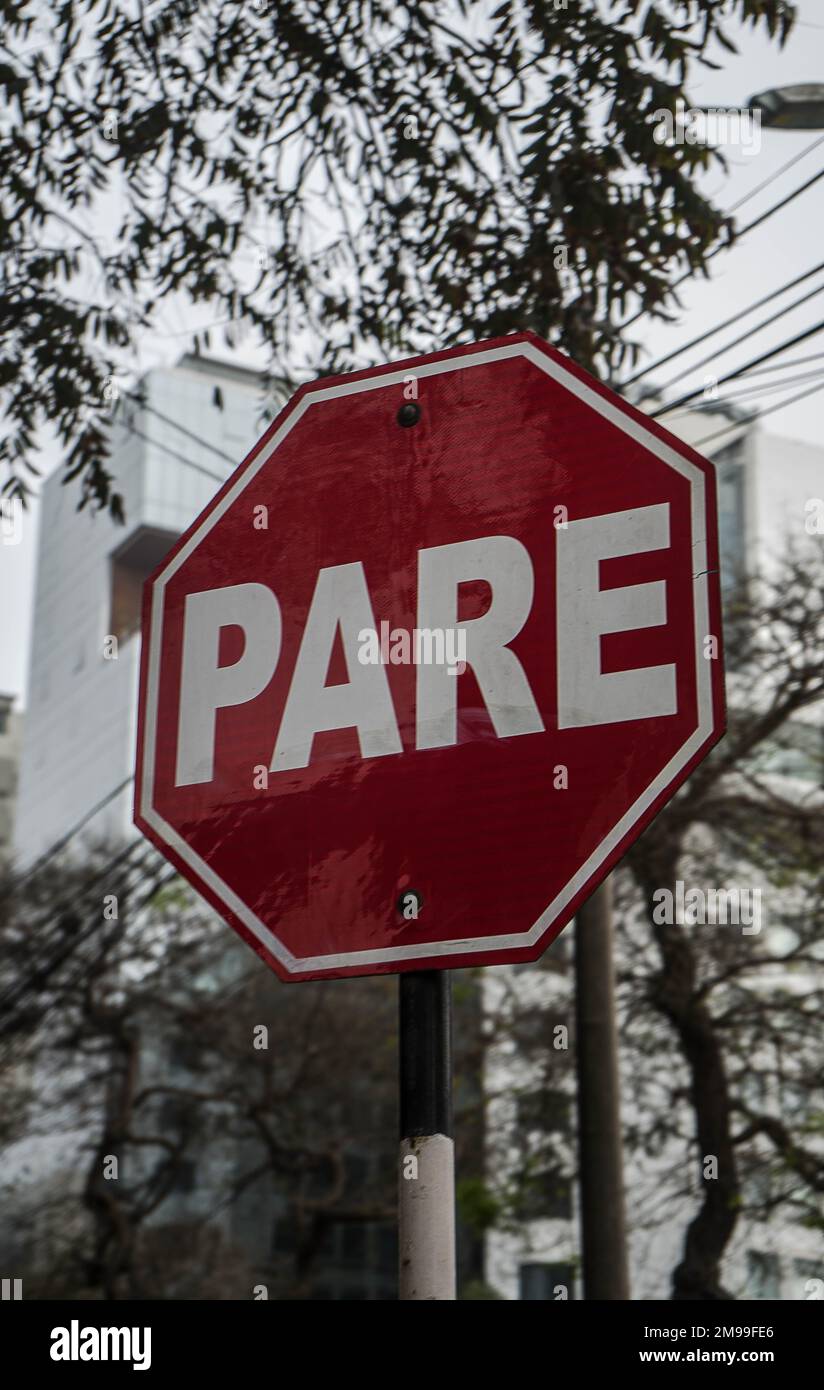 A vertical shot of the Spanish word "Pare" sign with the background of ...