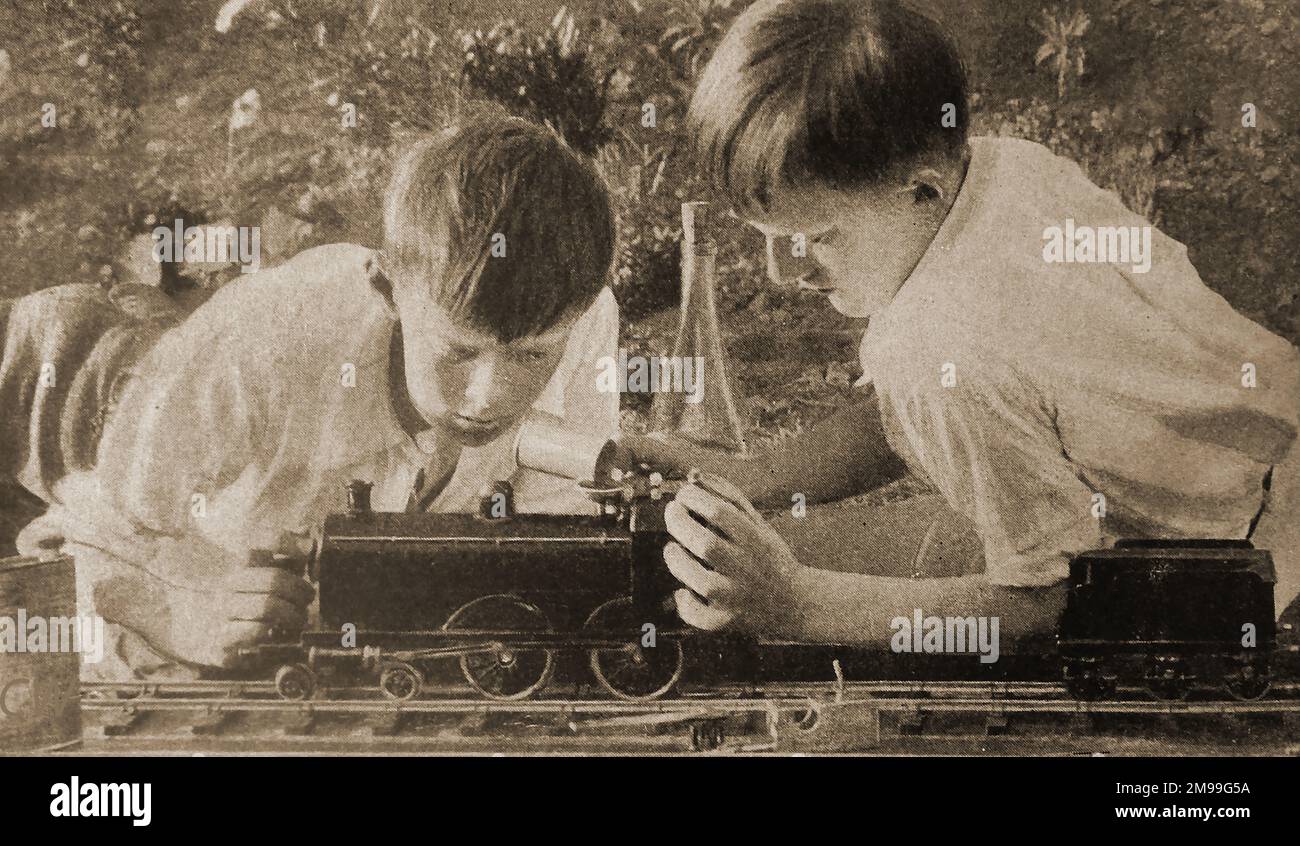 1930- Two schoolboys play with their model railway locomotive Stock ...
