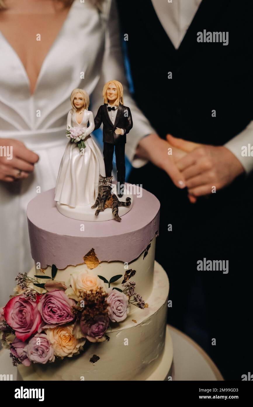 Three-level wedding cake with figures of people on it Stock Photo - Alamy