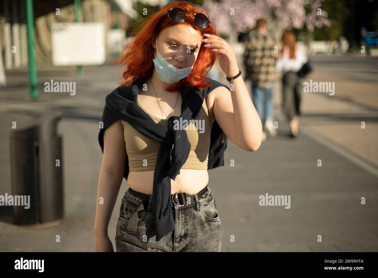 Girl in mask feels bad. Girl is dizzy on street. Feeling unwell in city ...