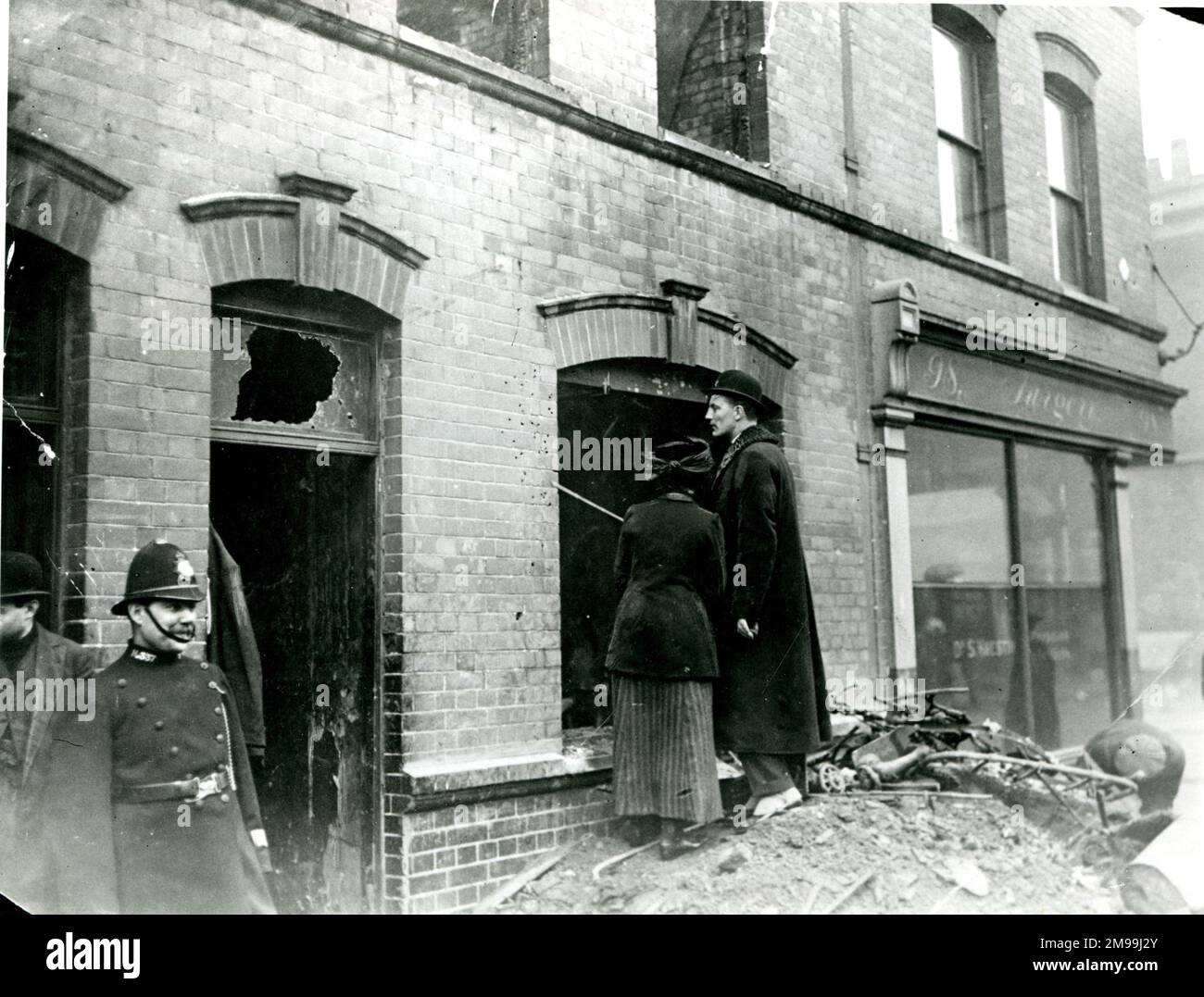 People looking at bullet holes after the Sidney Street Siege, London ...