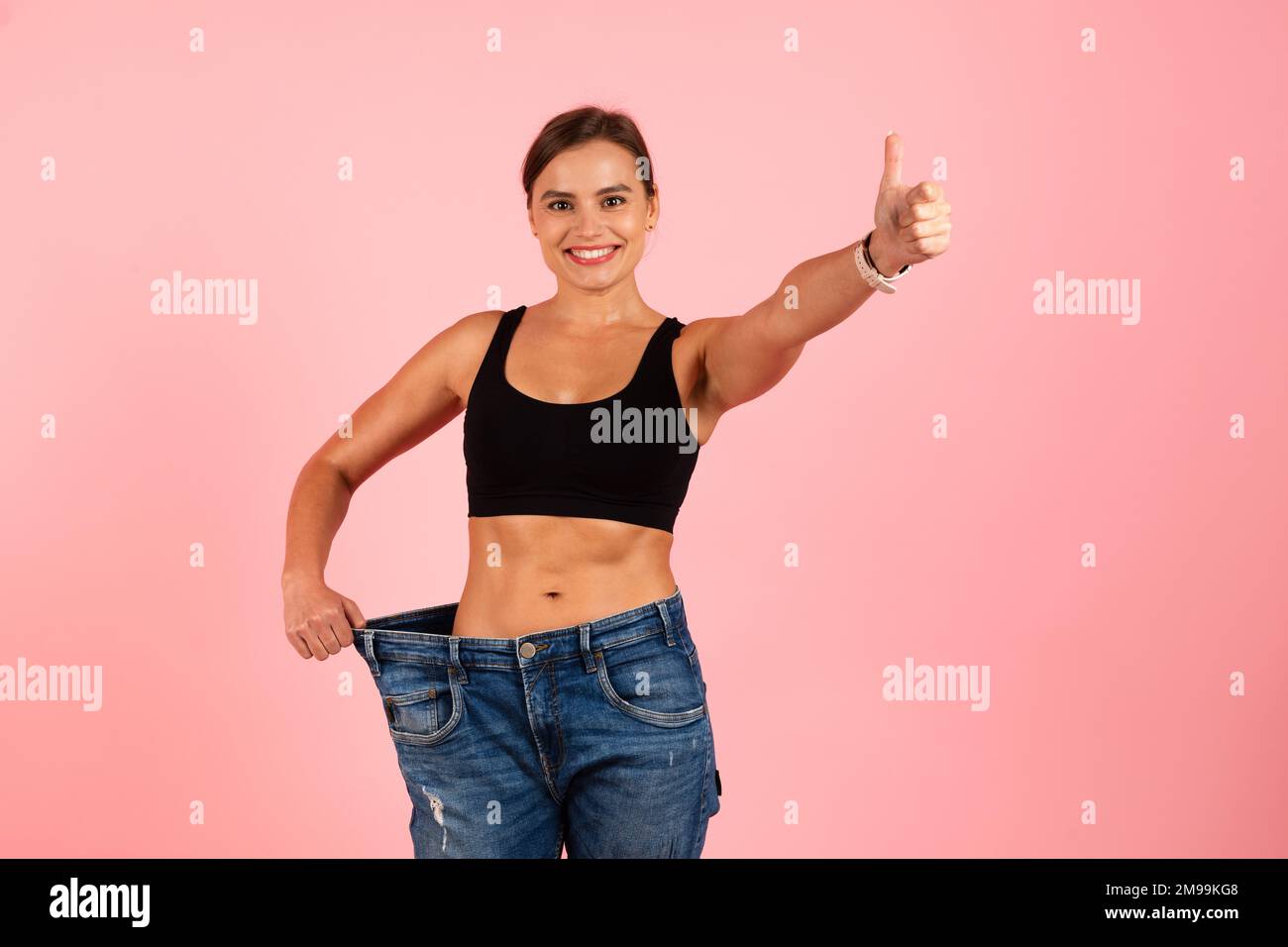 Successful Diet. Happy Slim Woman Wearing Oversized Jeans And Showing ...