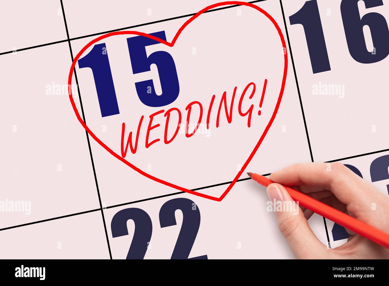 15th day of the month. Hand writing text WEDDING and drawing a red ...
