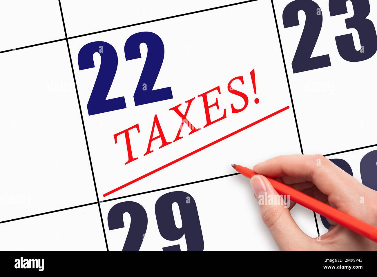 22nd day of the month. Hand writing text TAXES and drawing a line on ...
