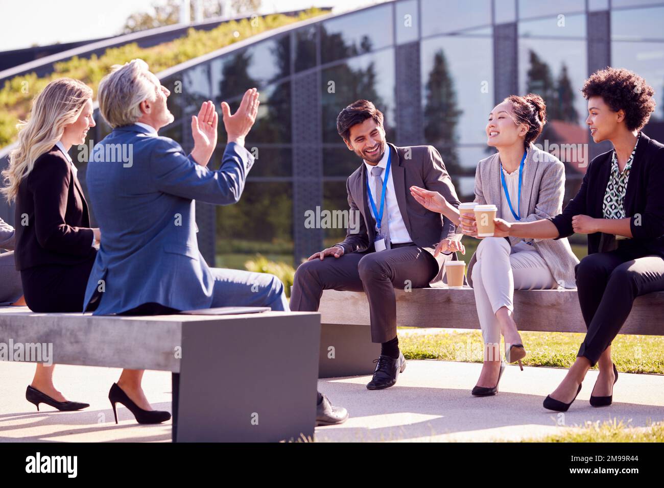 Multi-Cultural Business Team Sitting Outside Office For Coffee Break ...