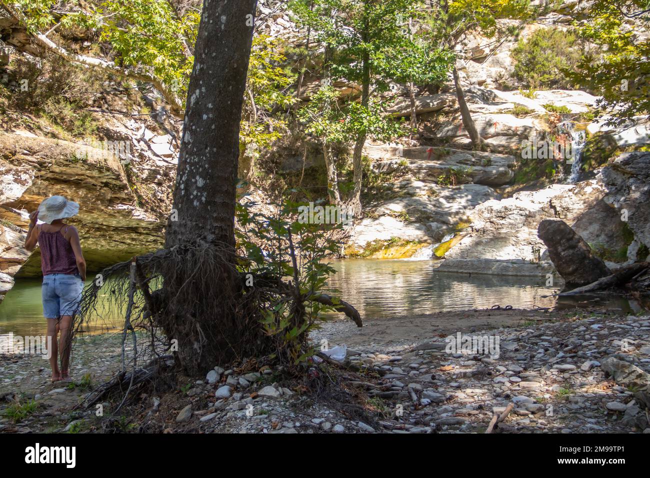 Young woman dressed in summer clothes enjoying by walking barefoot in ...