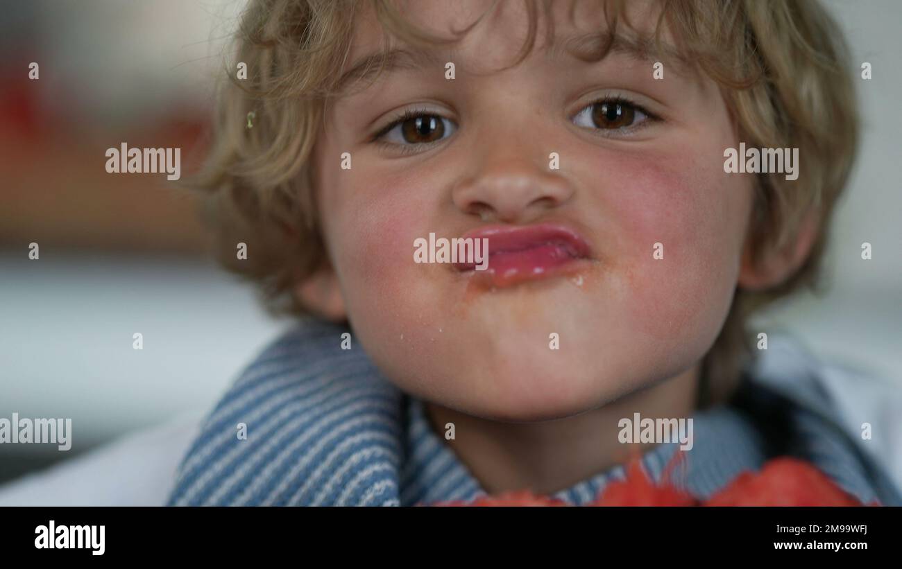 Parent putting napkin on son neck, child eating watermelon fruit Stock ...