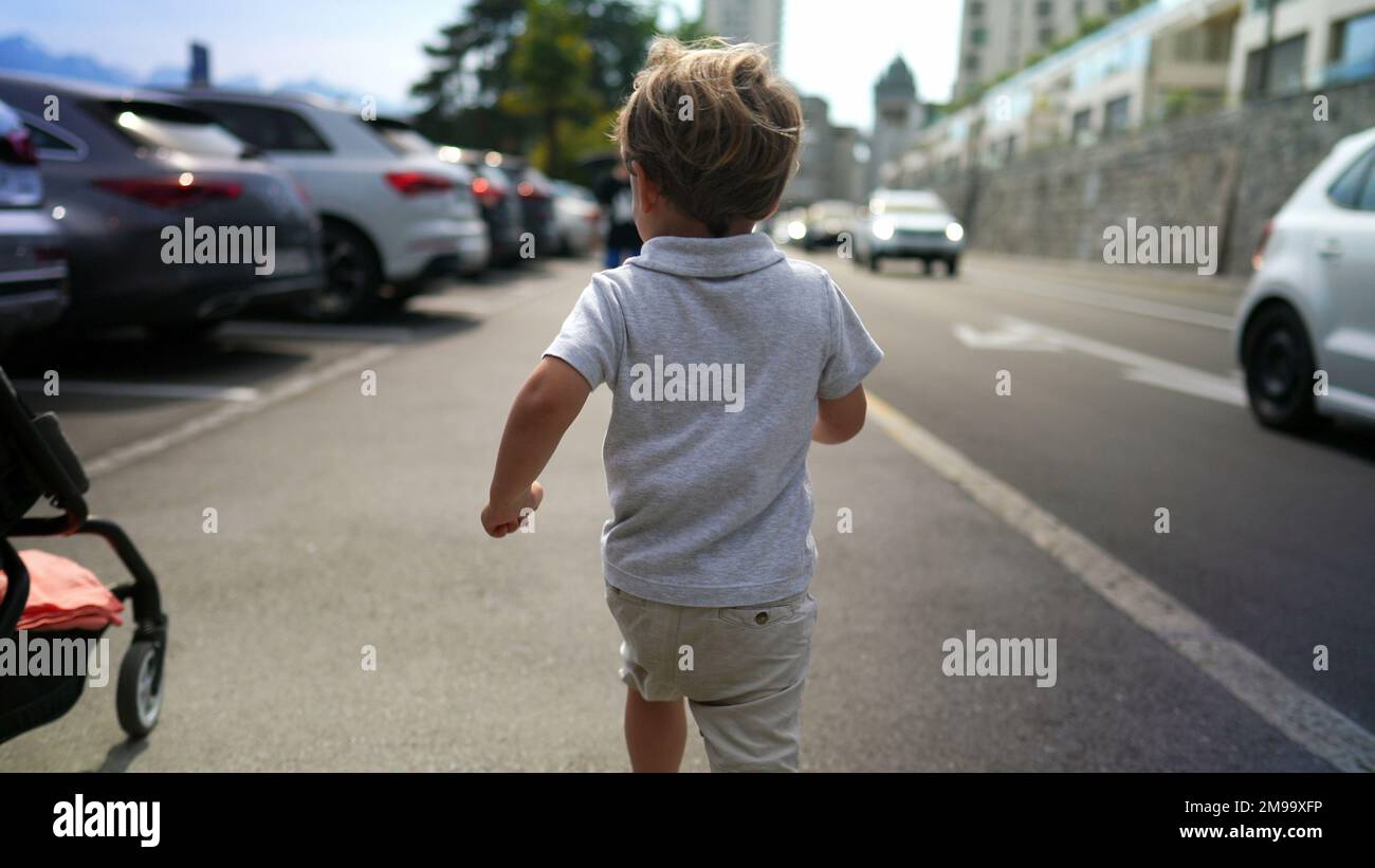 Little boy running outside in street sidewalk Stock Photo - Alamy