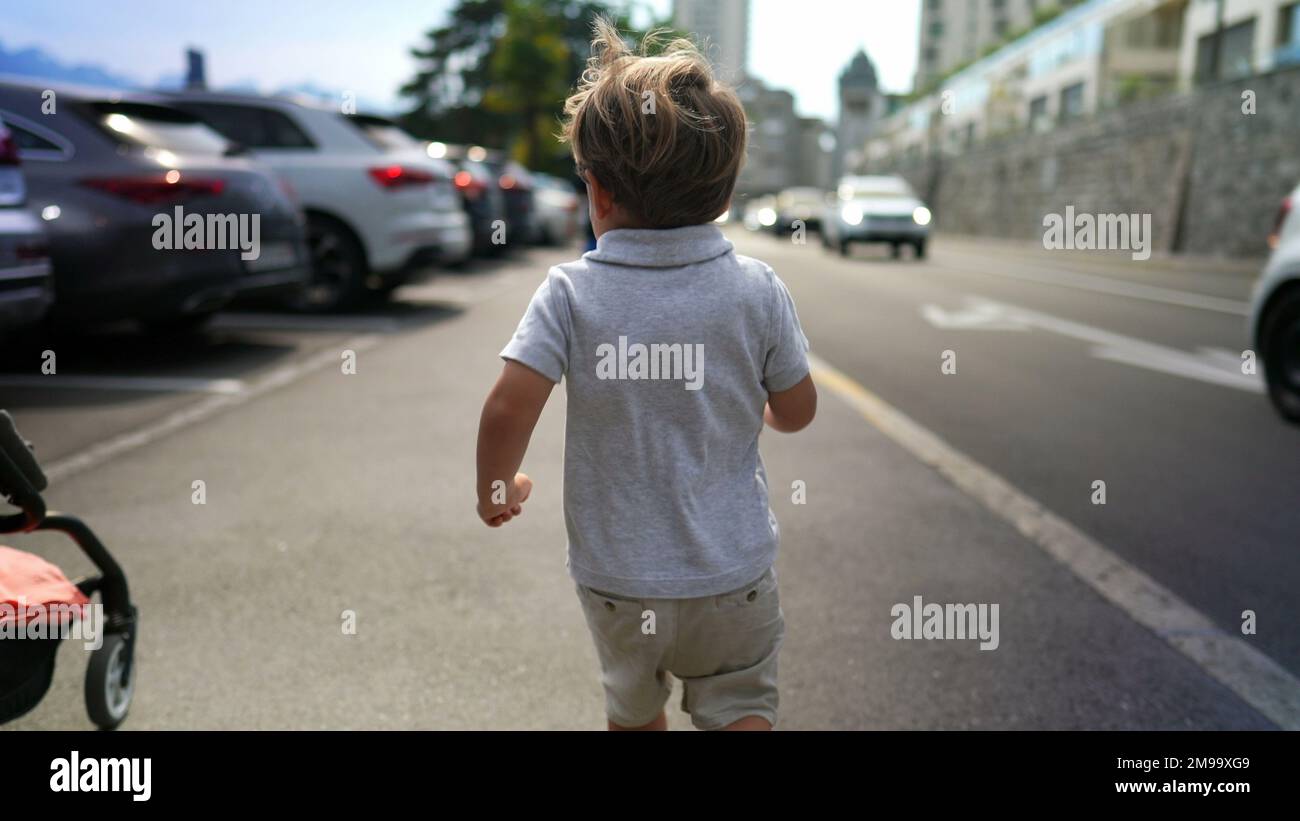 Little boy running outside in street sidewalk Stock Photo - Alamy