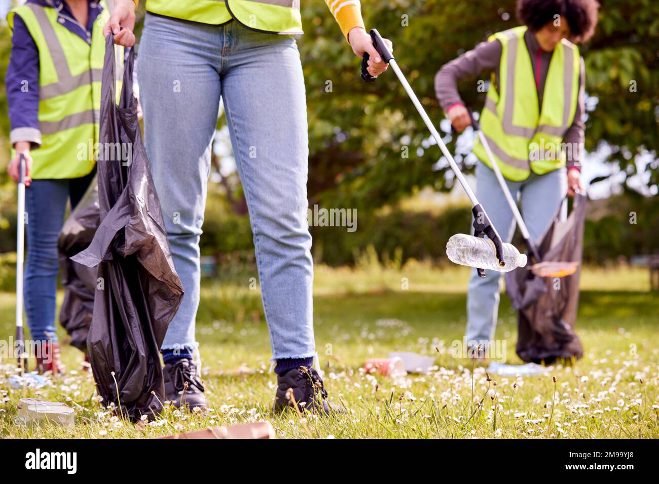 Close Up Of Female Volunteers Picking Up Litter In The Countryside Close Up Of Female Volunteers Picking Up Litter In The Countryside