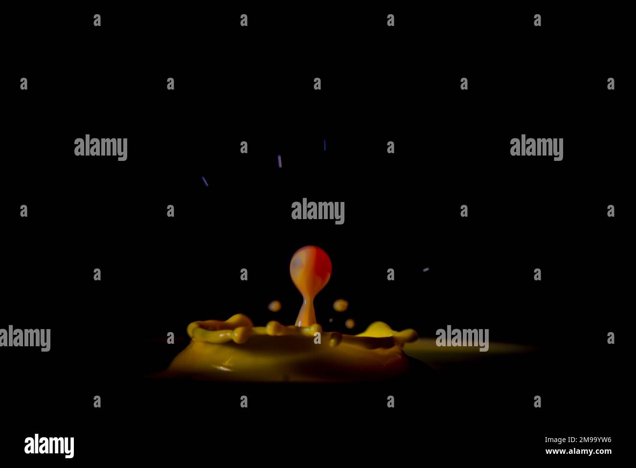 Color fresh sweet milk drops into another color of milk in cup with ...