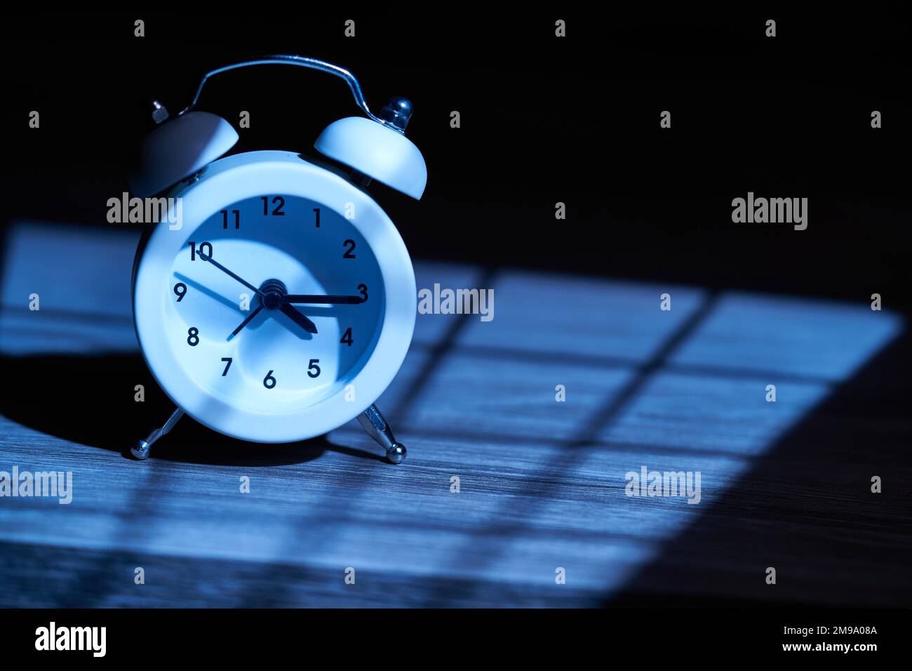 A retro style alarm clock on wooden background Stock Photo - Alamy