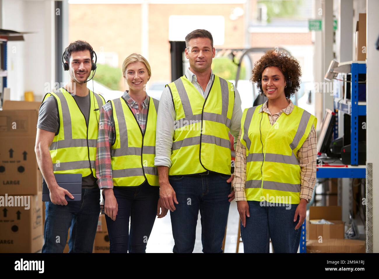 Portrait Of Team Wearing Headsets In Logistics Distribution Warehouse ...