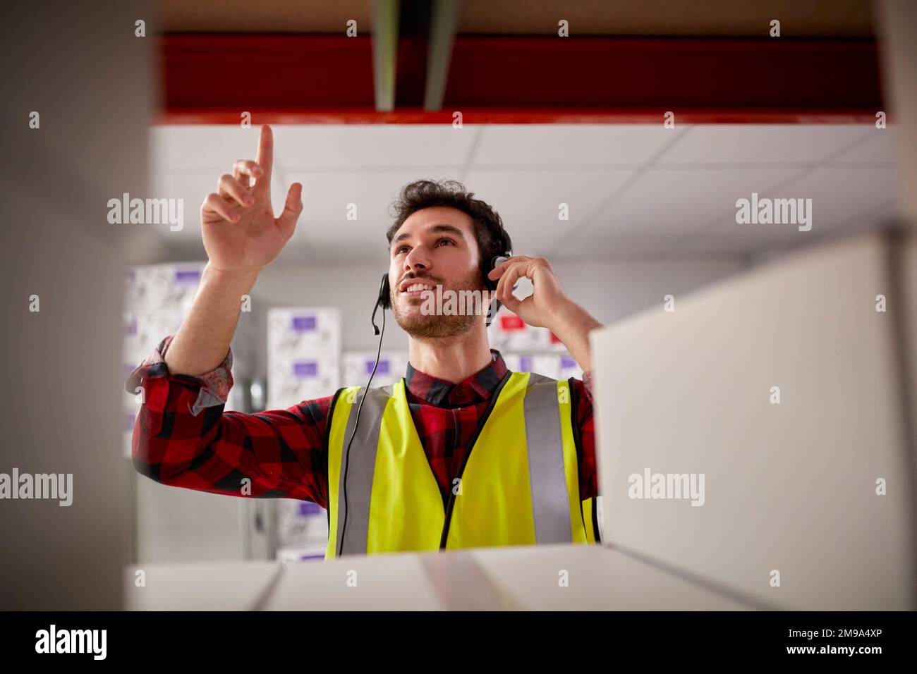 Male Worker Wearing Headset In Logistics Distribution Warehouse Taking ...