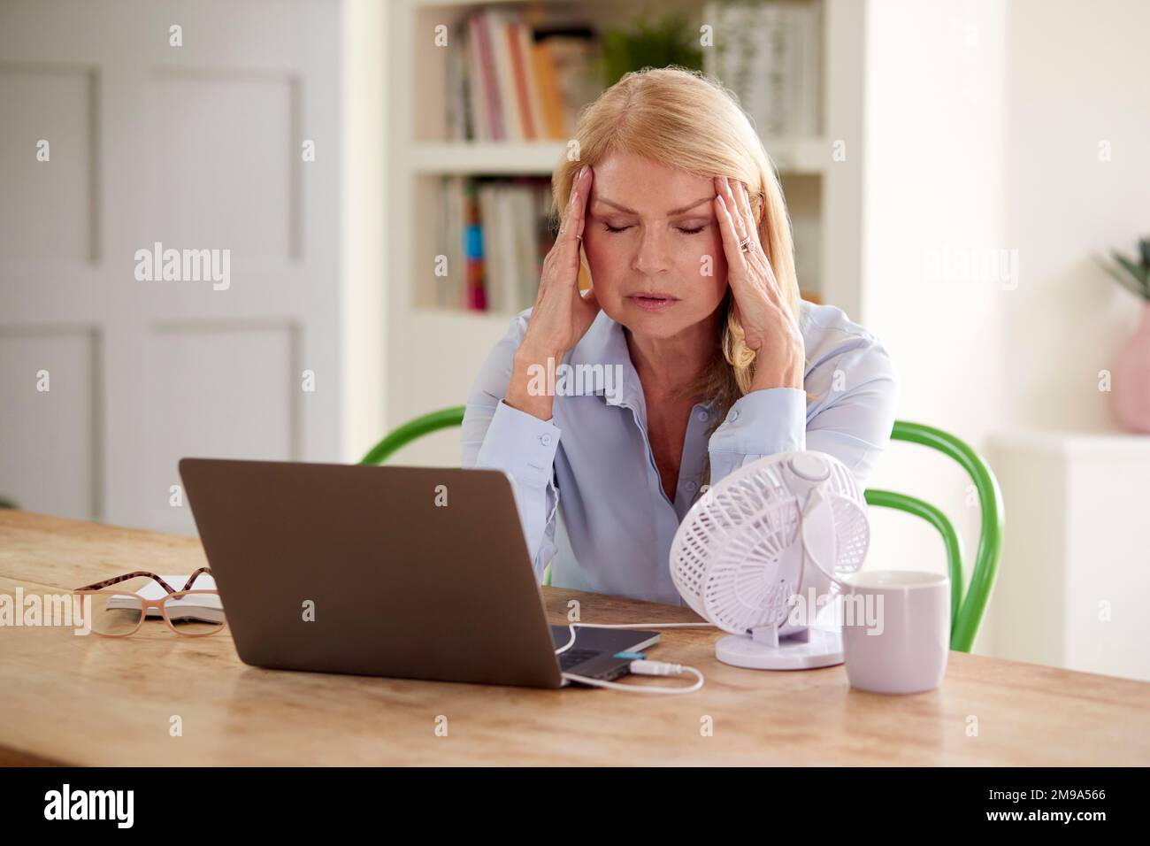Menopausal Mature Woman Having Hot Flush At Home Cooling Herself With ...
