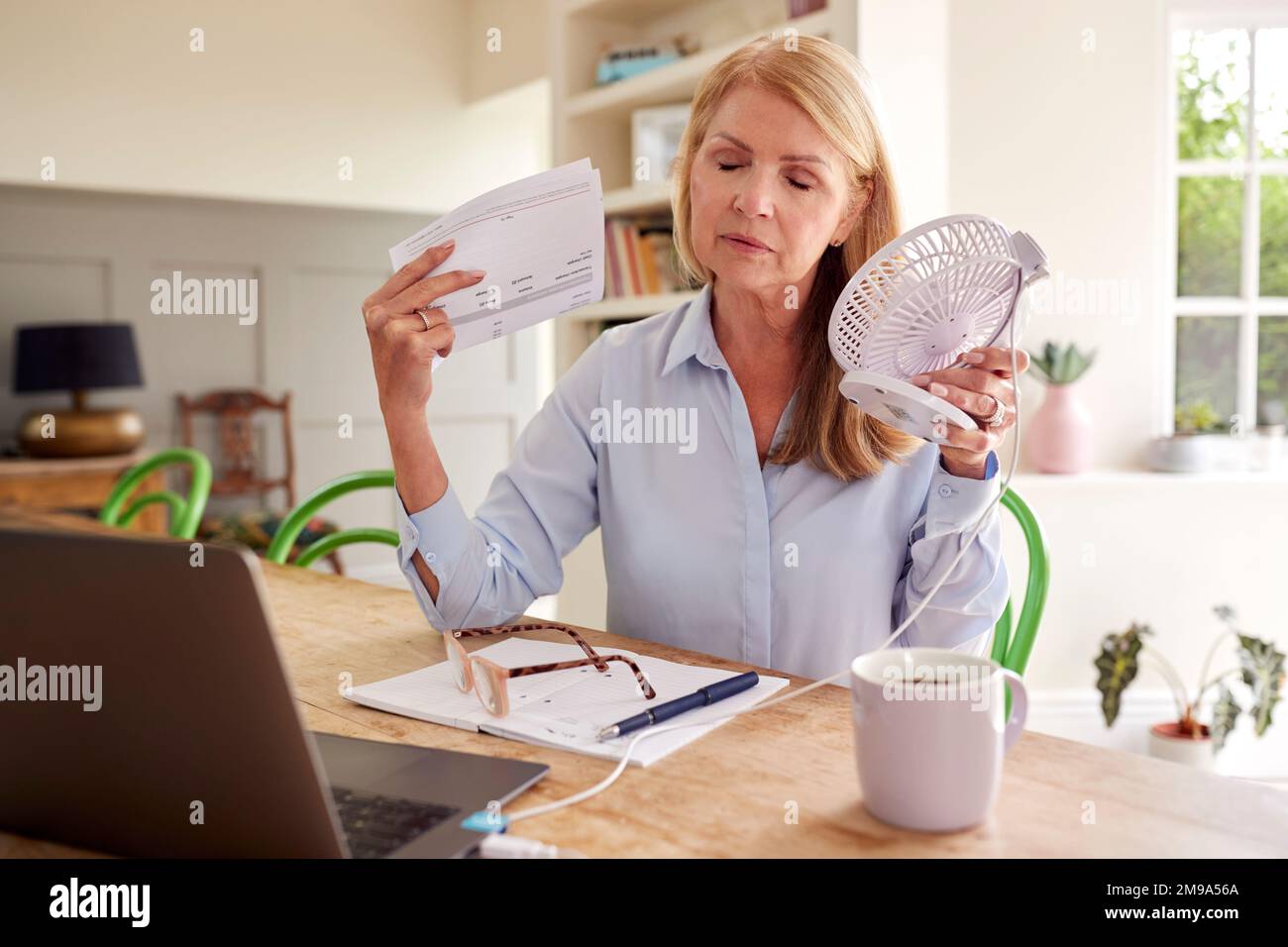 Menopausal Mature Woman Having Hot Flush At Home Cooling Herself With ...