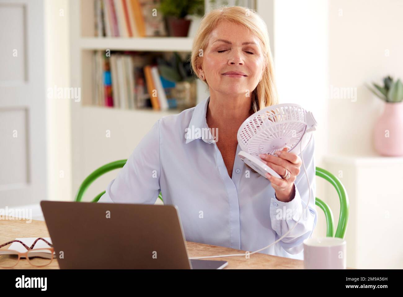 Menopausal Mature Woman Having Hot Flush At Home Cooling Herself With ...
