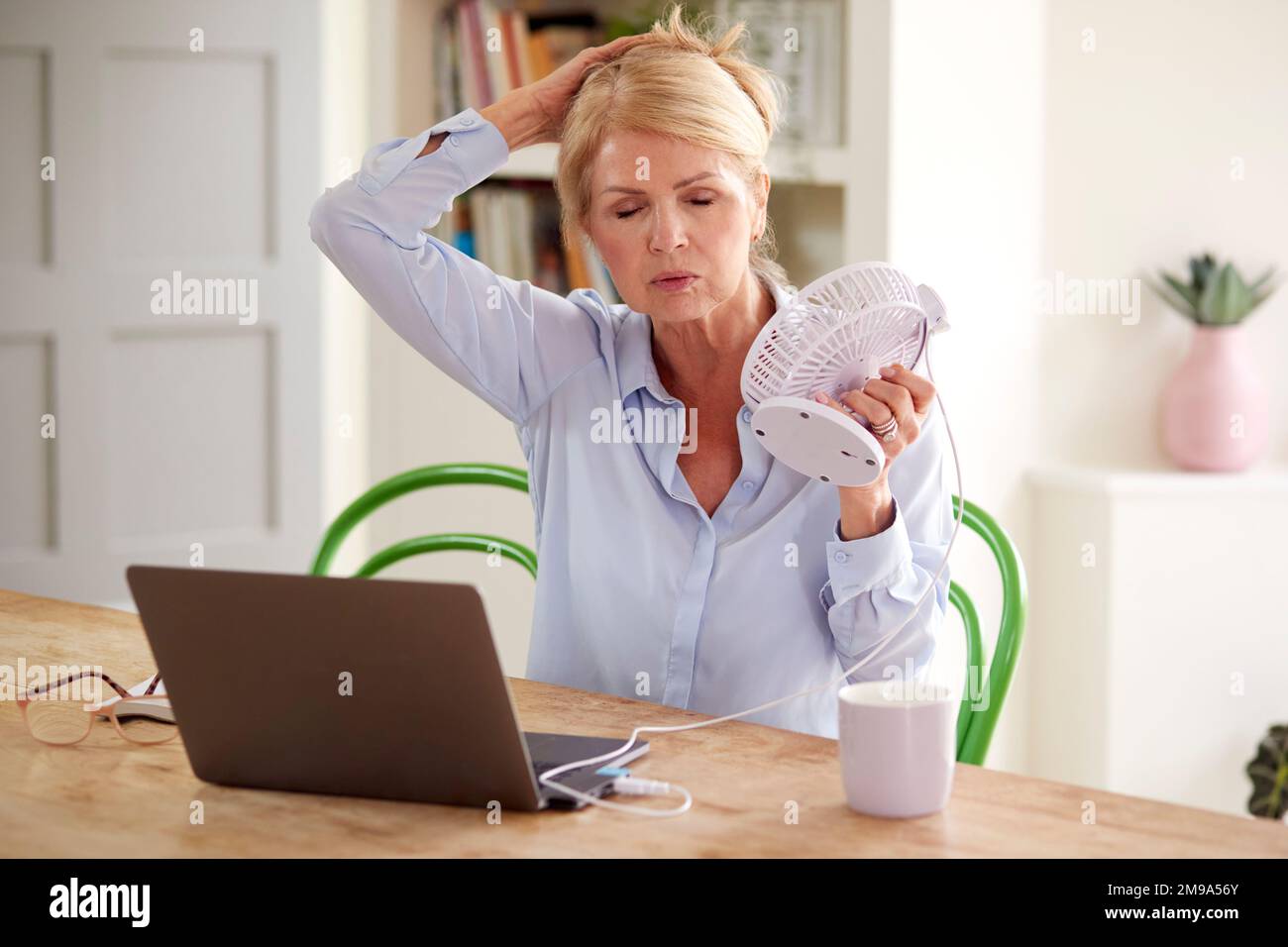 Menopausal Mature Woman Having Hot Flush At Home Cooling Herself With ...