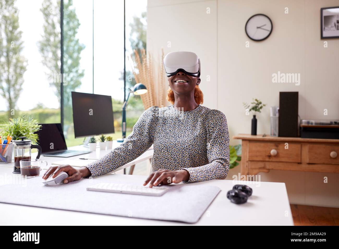 Woman Working From Home Office Sitting At Desk Wearing VR Headset Using ...